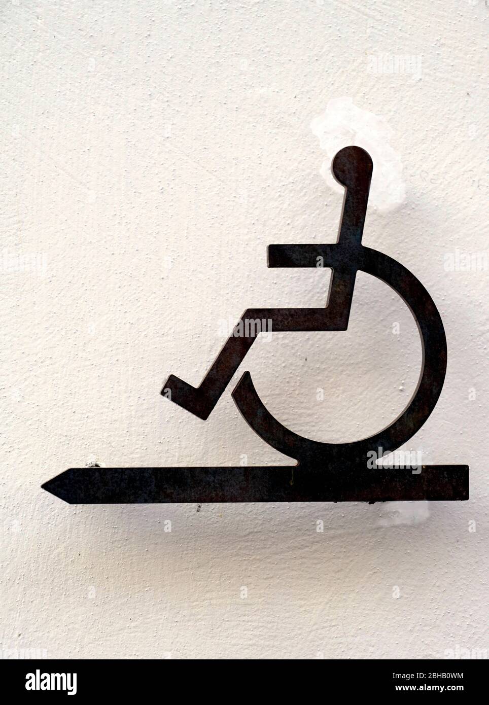 Wheelchair users, metal signs, signpost for handicapped entrance at a ...