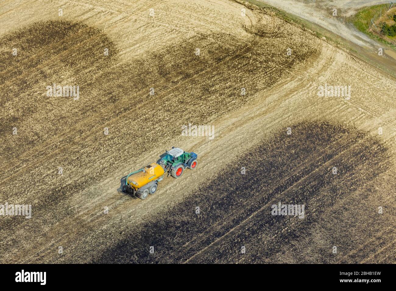 Aerial view of the spraying of manure with tractor on fields, Enkdorf ...