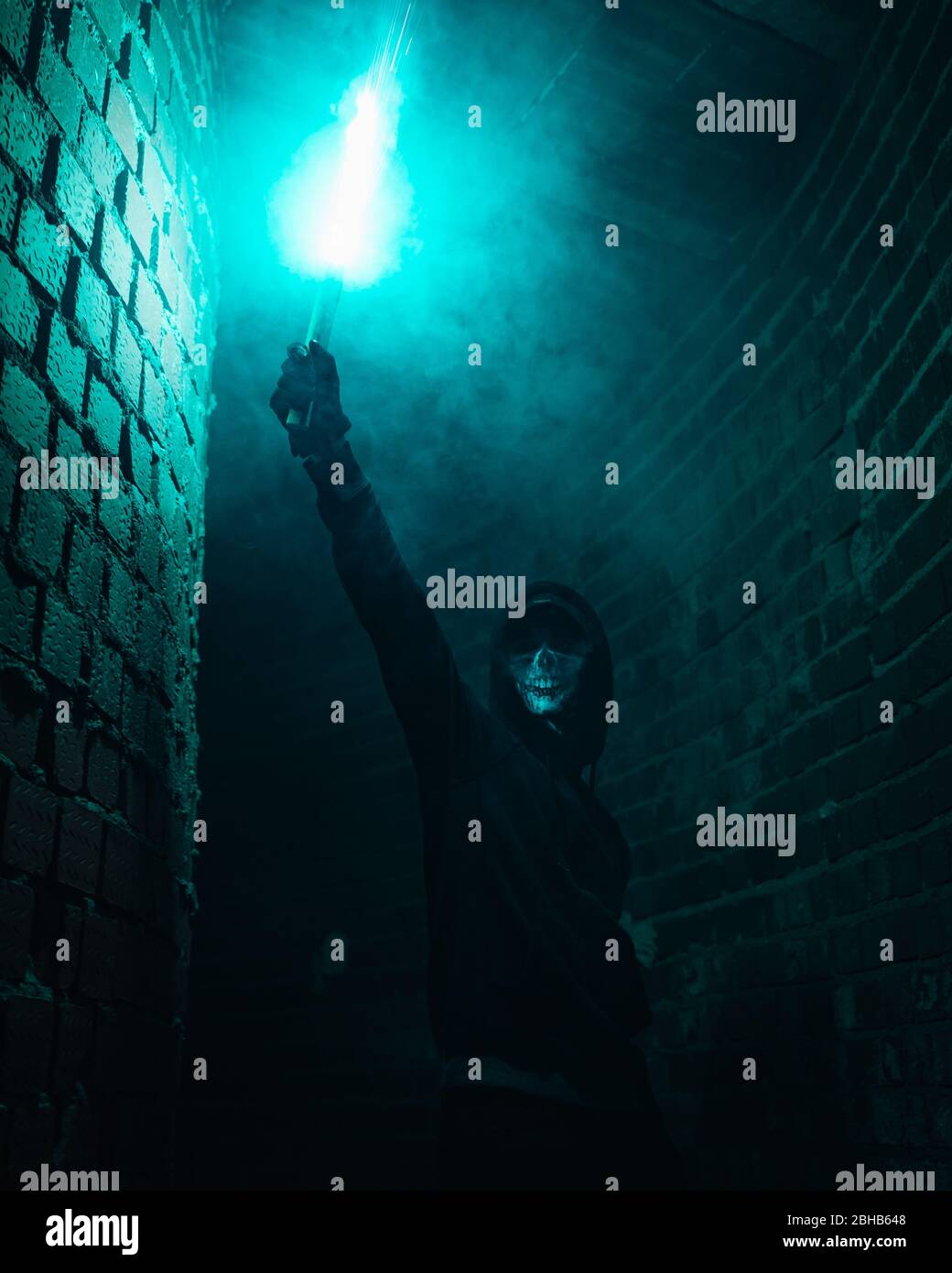 Man holding blue smoke flare in closed urban environment Stock Photo ...