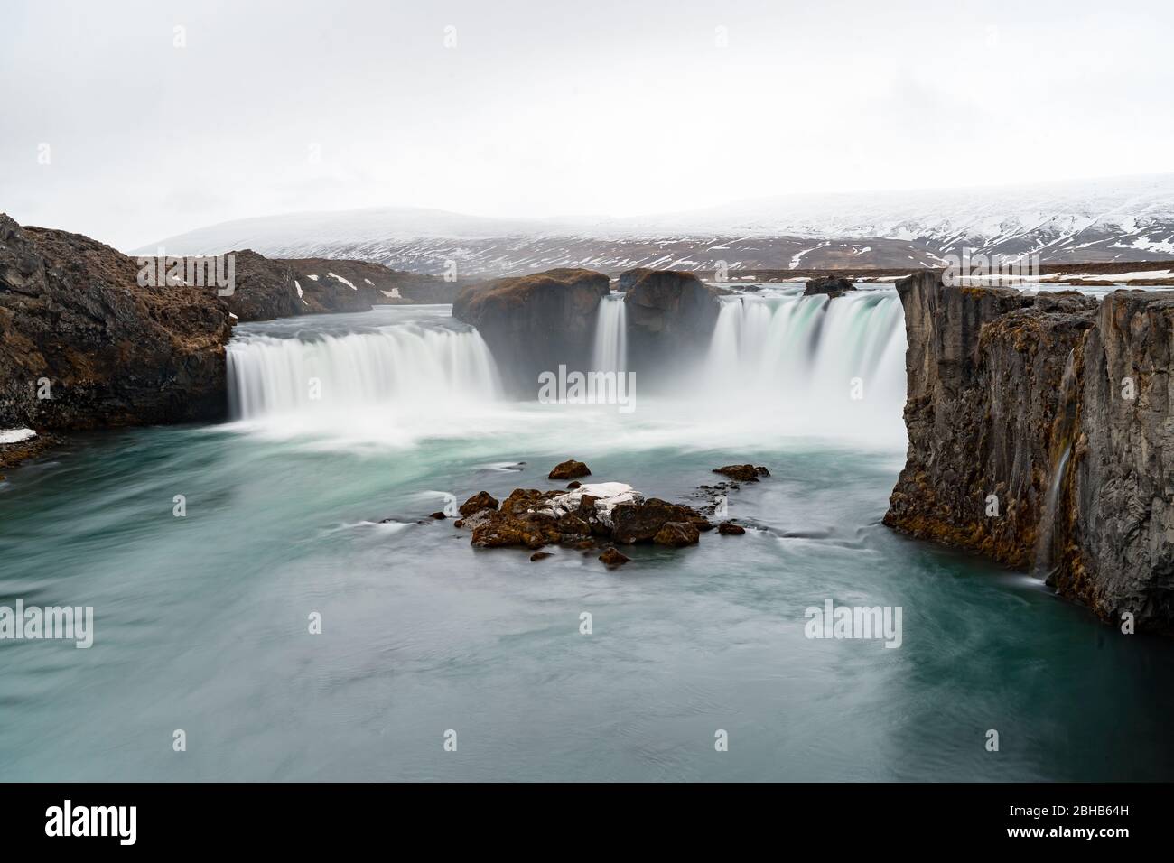 Famous godafoss waterfall in iceland in spring with snowy mountains ...