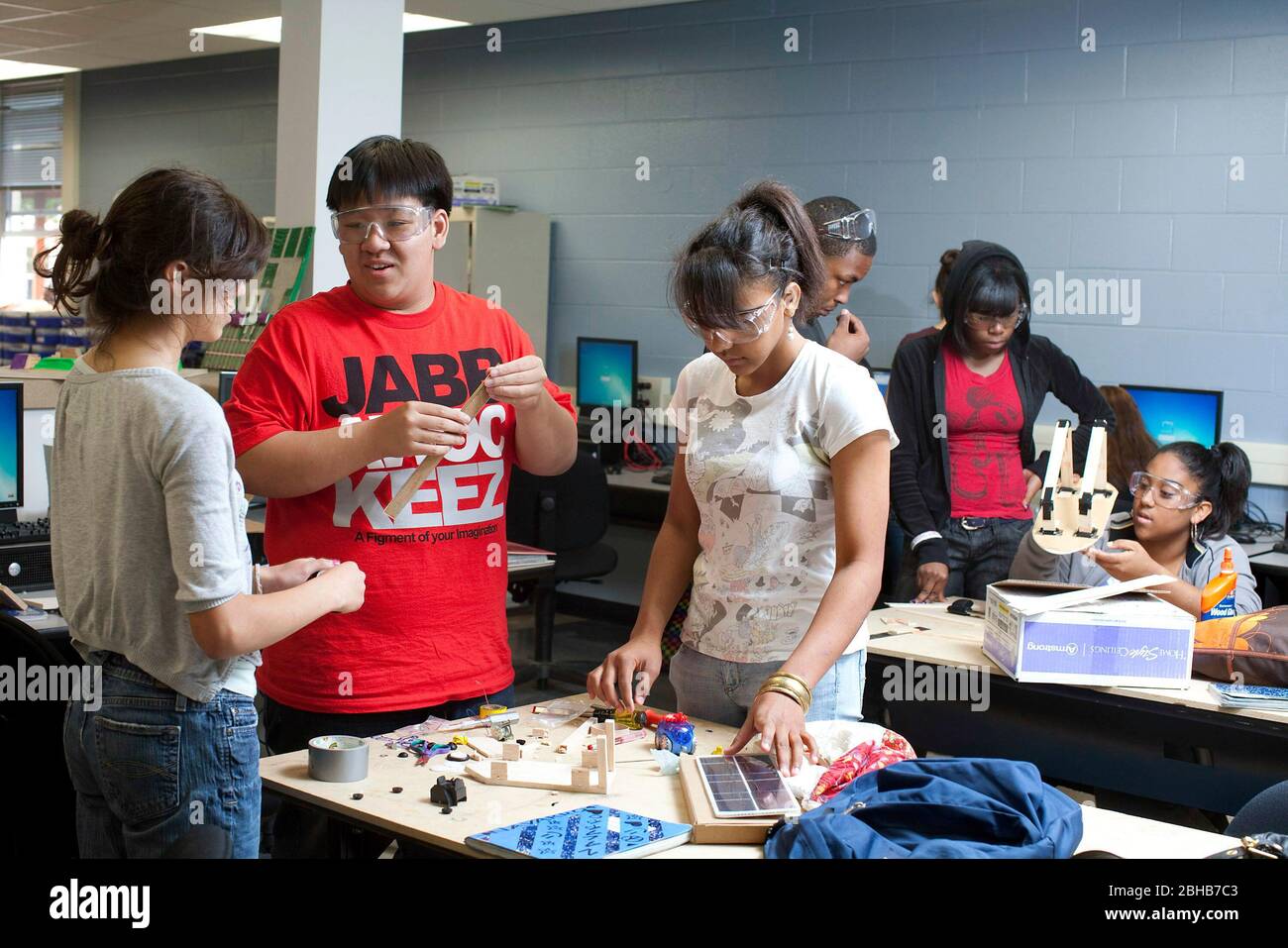 Students wearing safety goggles work together to construct model solar ...