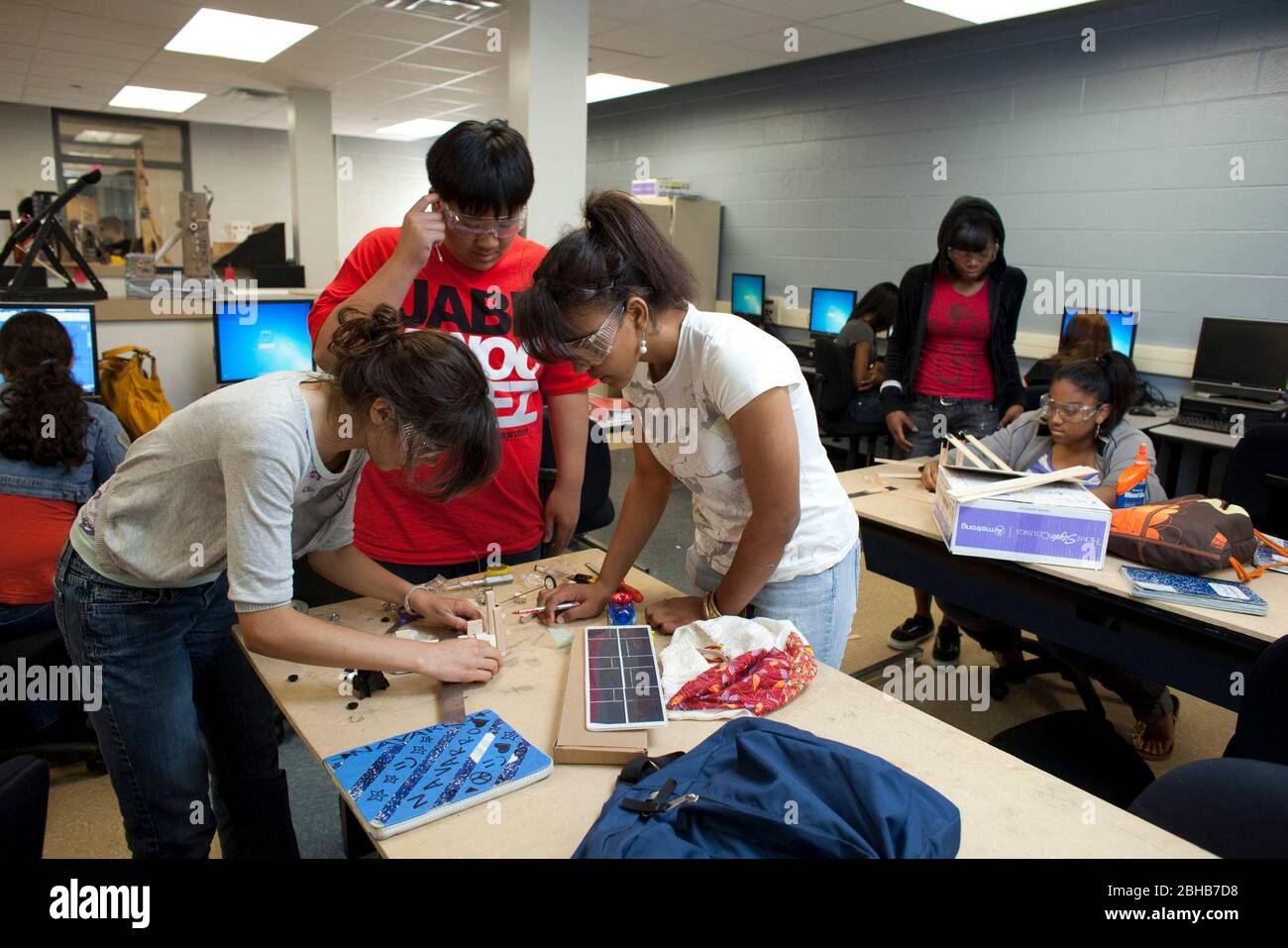 Students wearing safety goggles work together to construct model solar ...