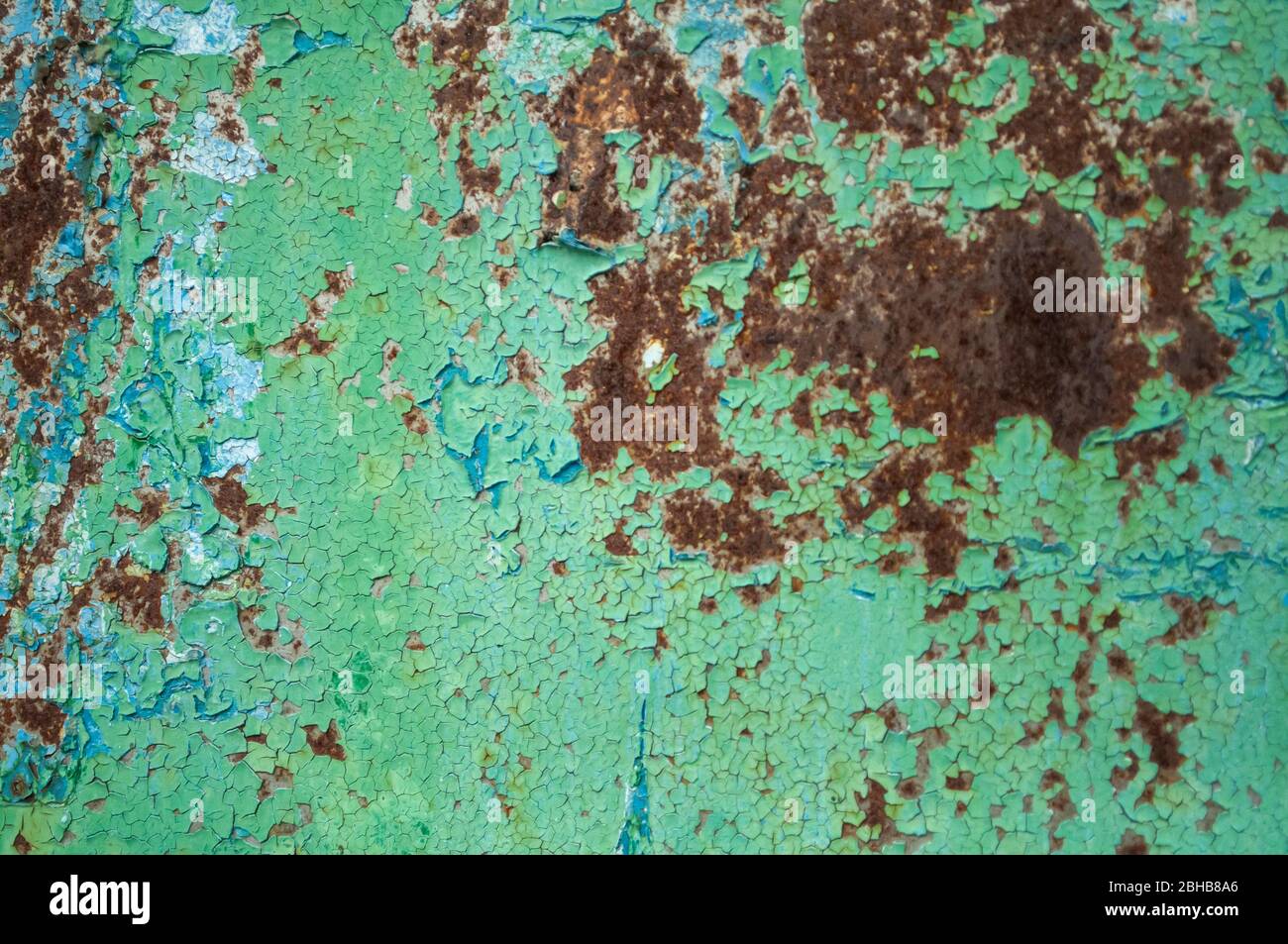 Metal painted with green paint, from which you can see the rust close ...