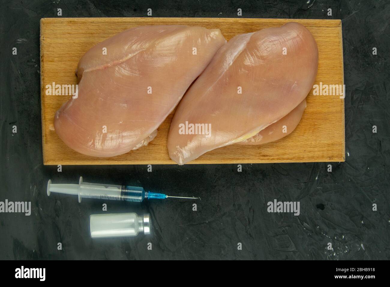 Injection syringe in raw chicken pieces, concept of injection of GMOs ...