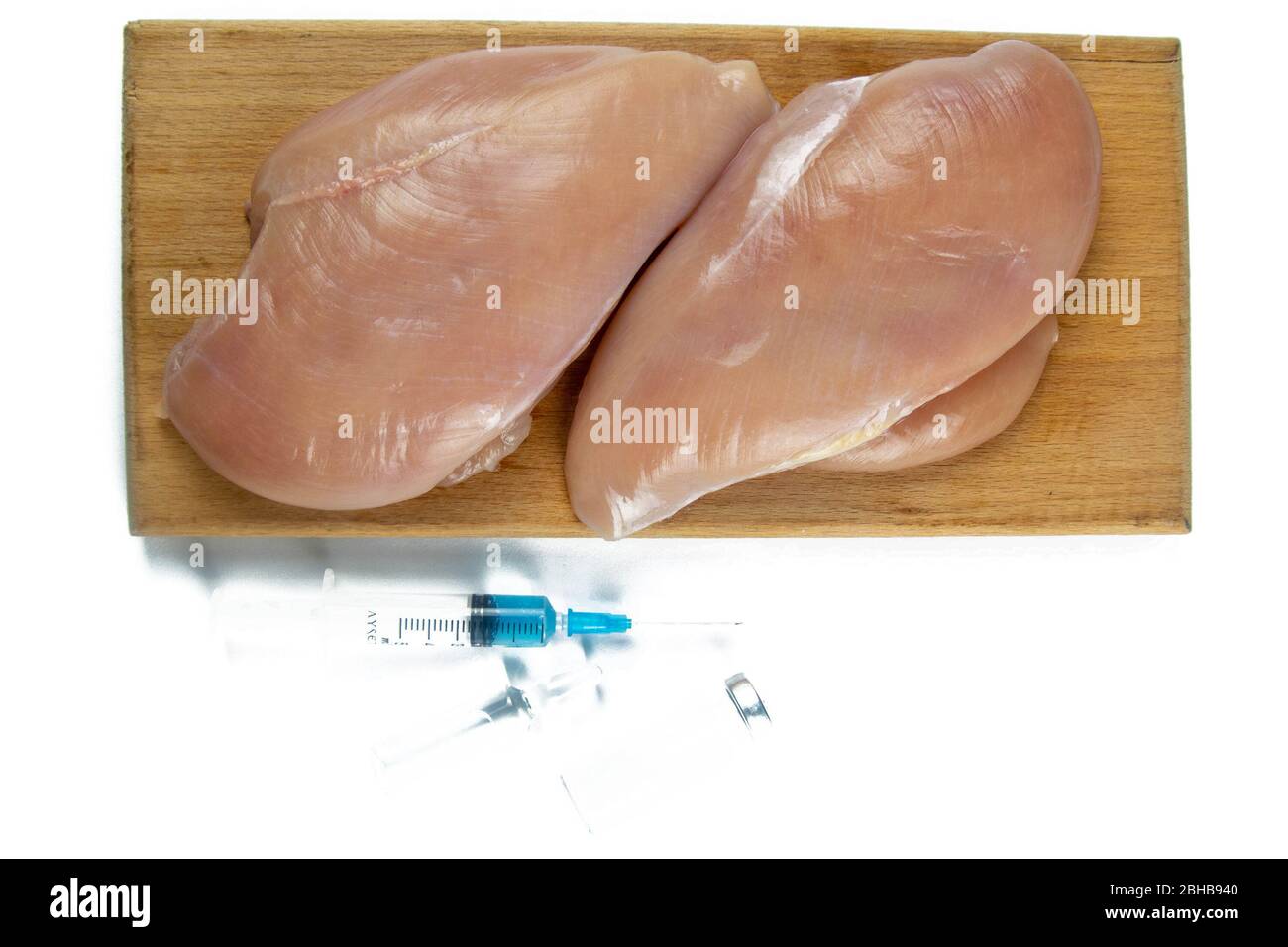 Syringe with liquid being injected to a piece of meat. Conceptual ...