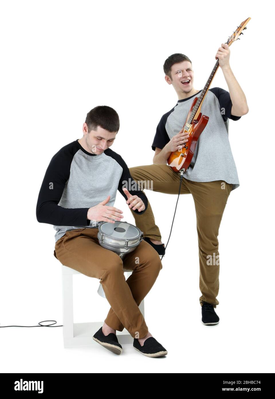 Two handsome young men with musical instruments isolated on white Stock ...