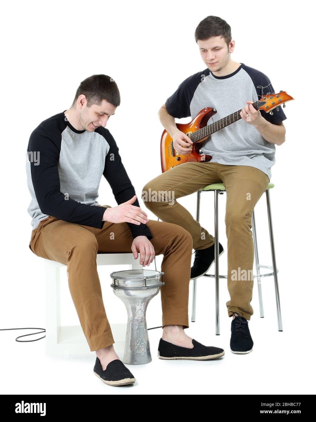 Two handsome young men with musical instruments isolated on white Stock ...