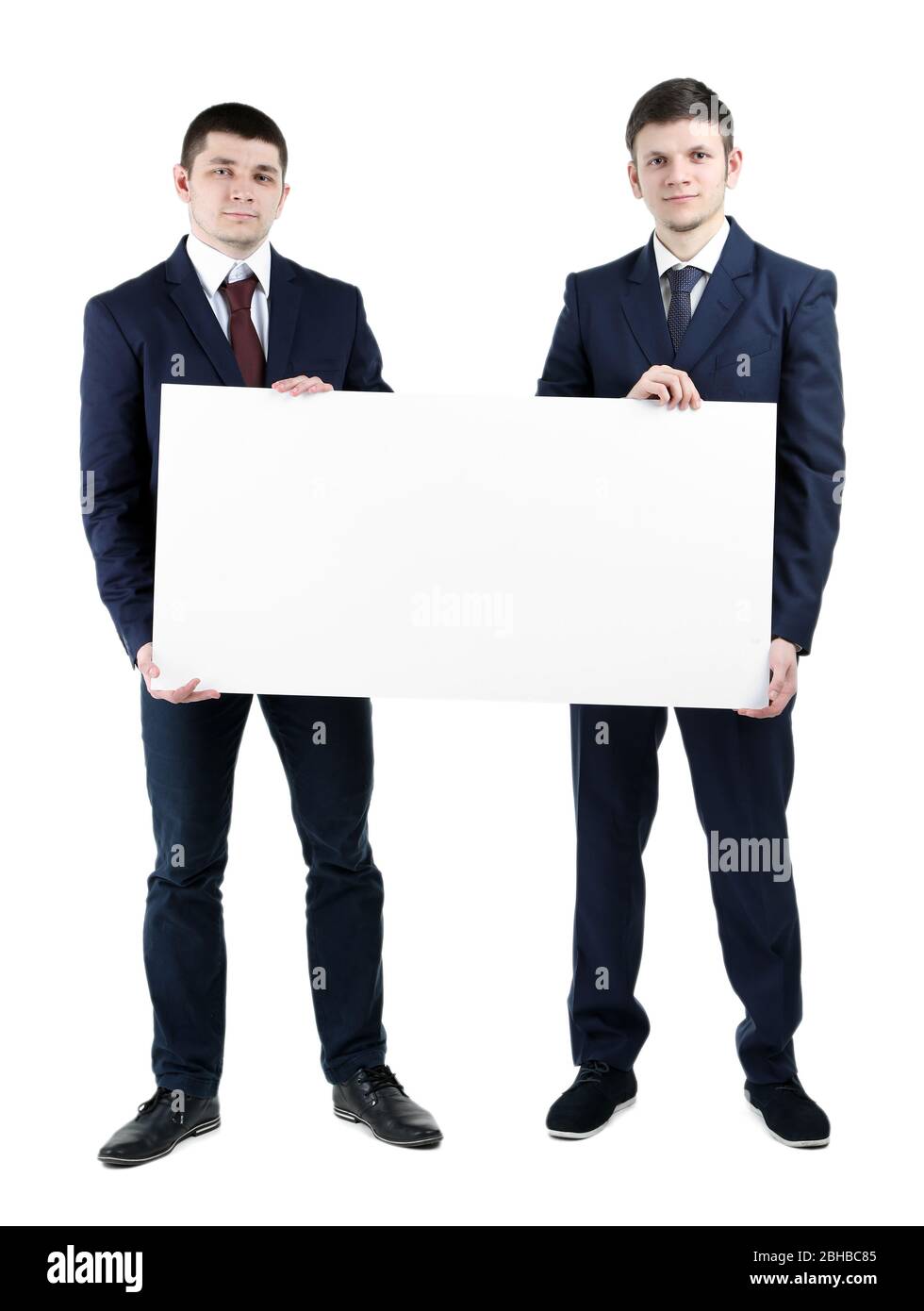 Two handsome businessmen holding blank poster isolated on white Stock ...