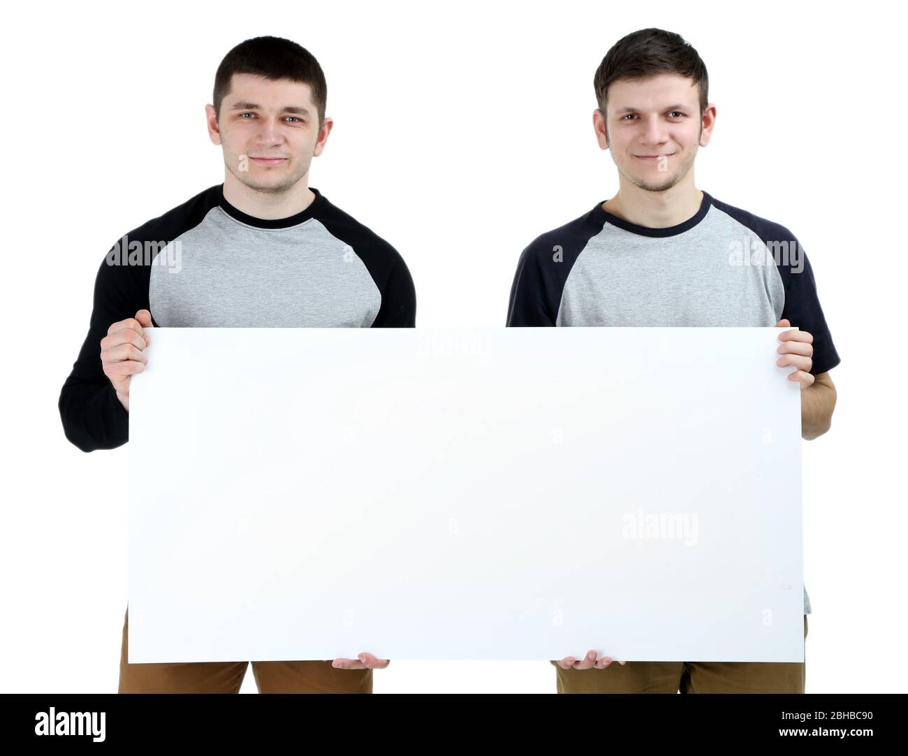 Two handsome young men holding blank poster isolated on white Stock ...