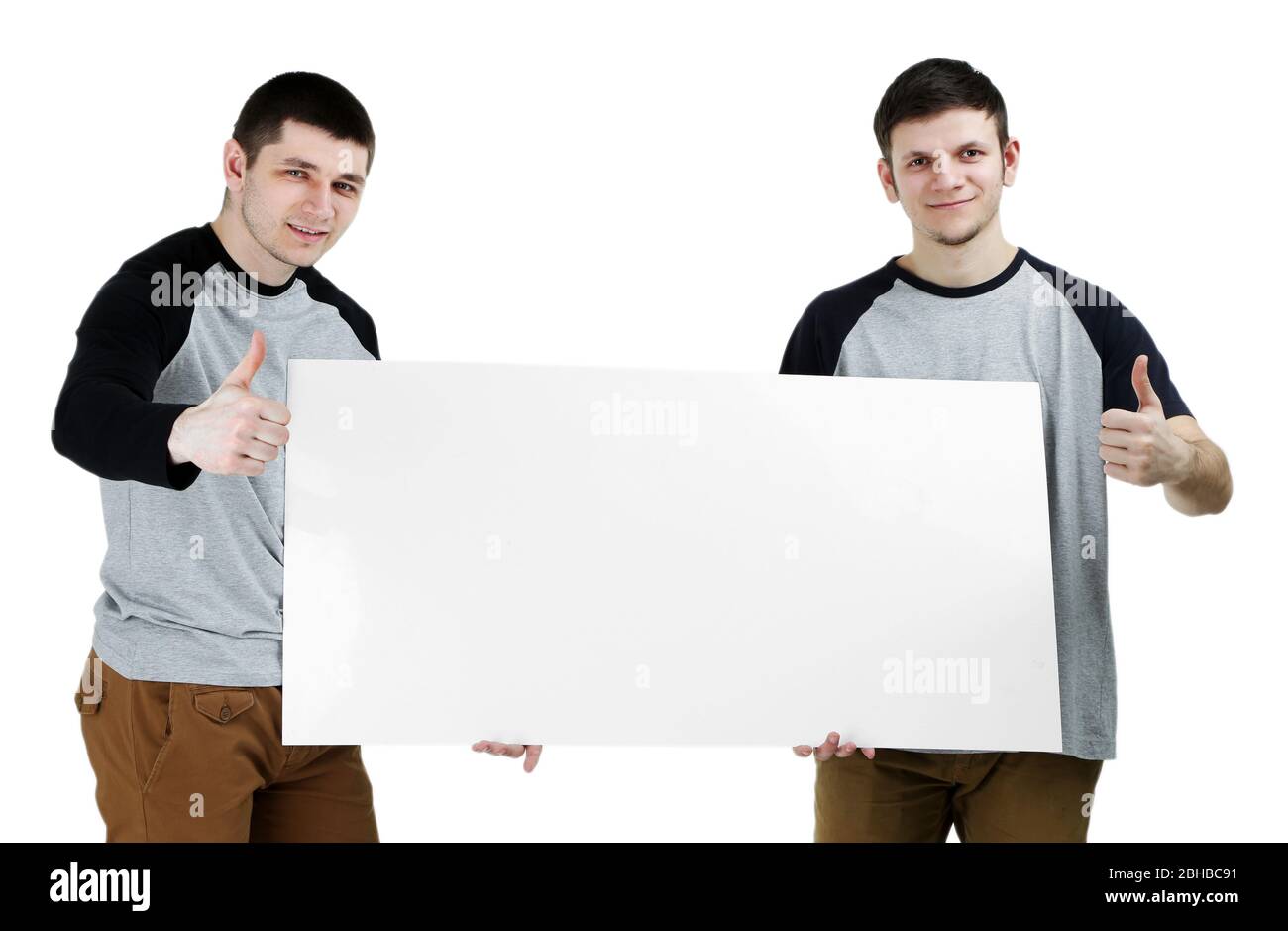 Two handsome young men holding blank poster isolated on white Stock ...