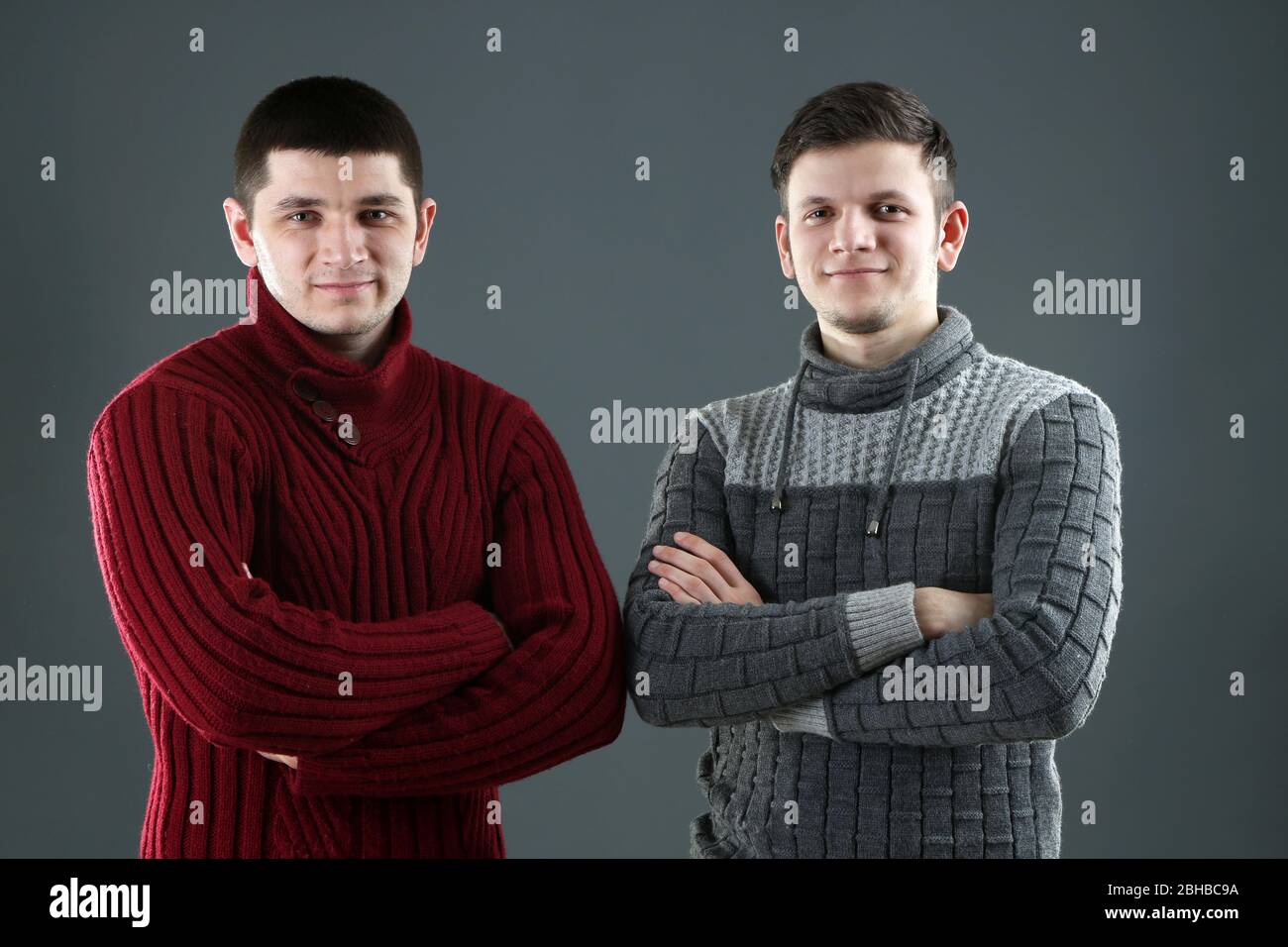 Two handsome young men on gray background Stock Photo - Alamy