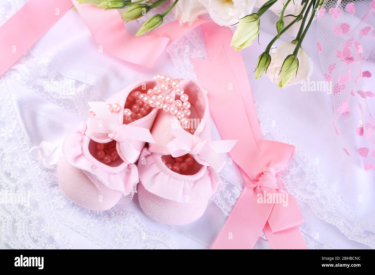 Baby shoe and cross for Christening Stock Photo - Alamy