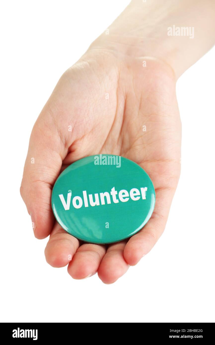Round volunteer button in hand isolated on white Stock Photo - Alamy