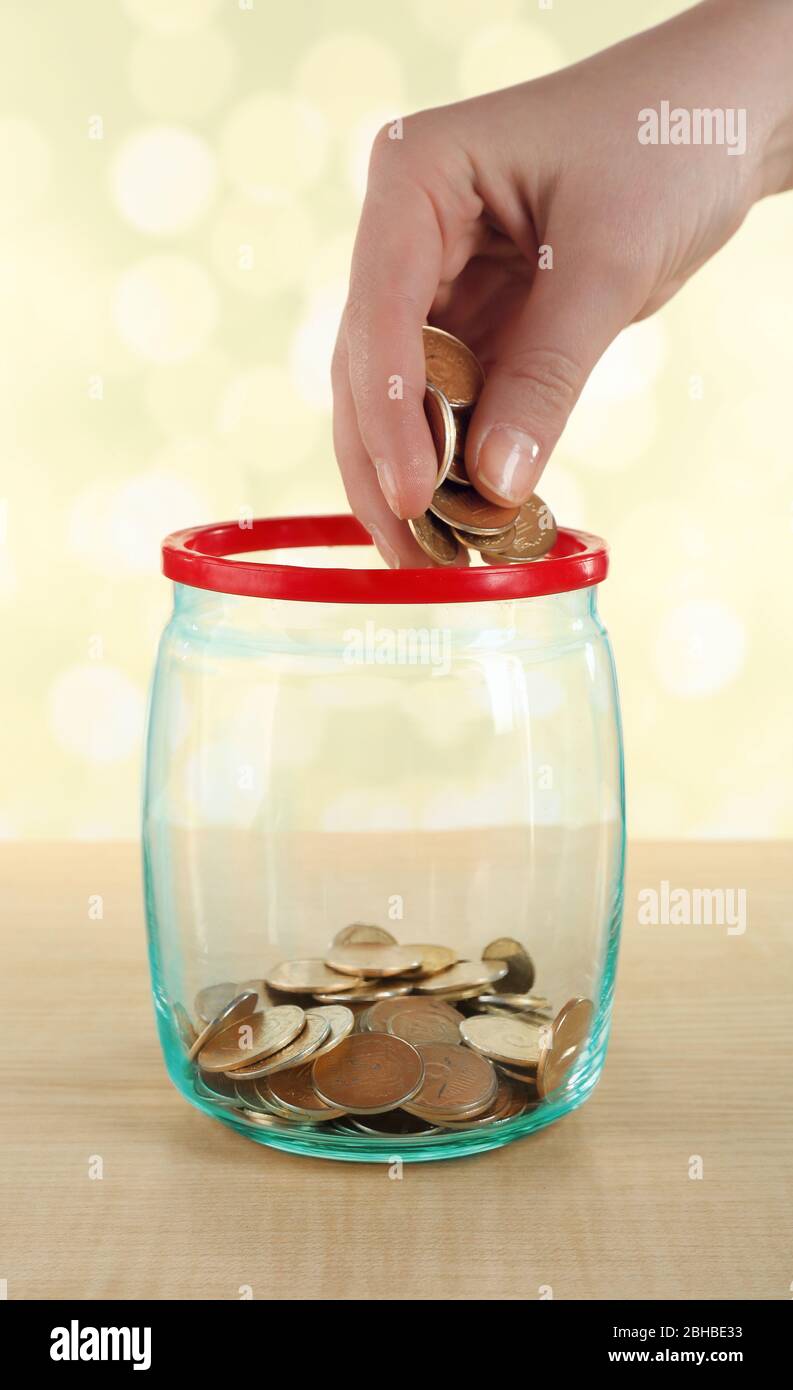 Female hand putting coins hi-res stock photography and images - Alamy