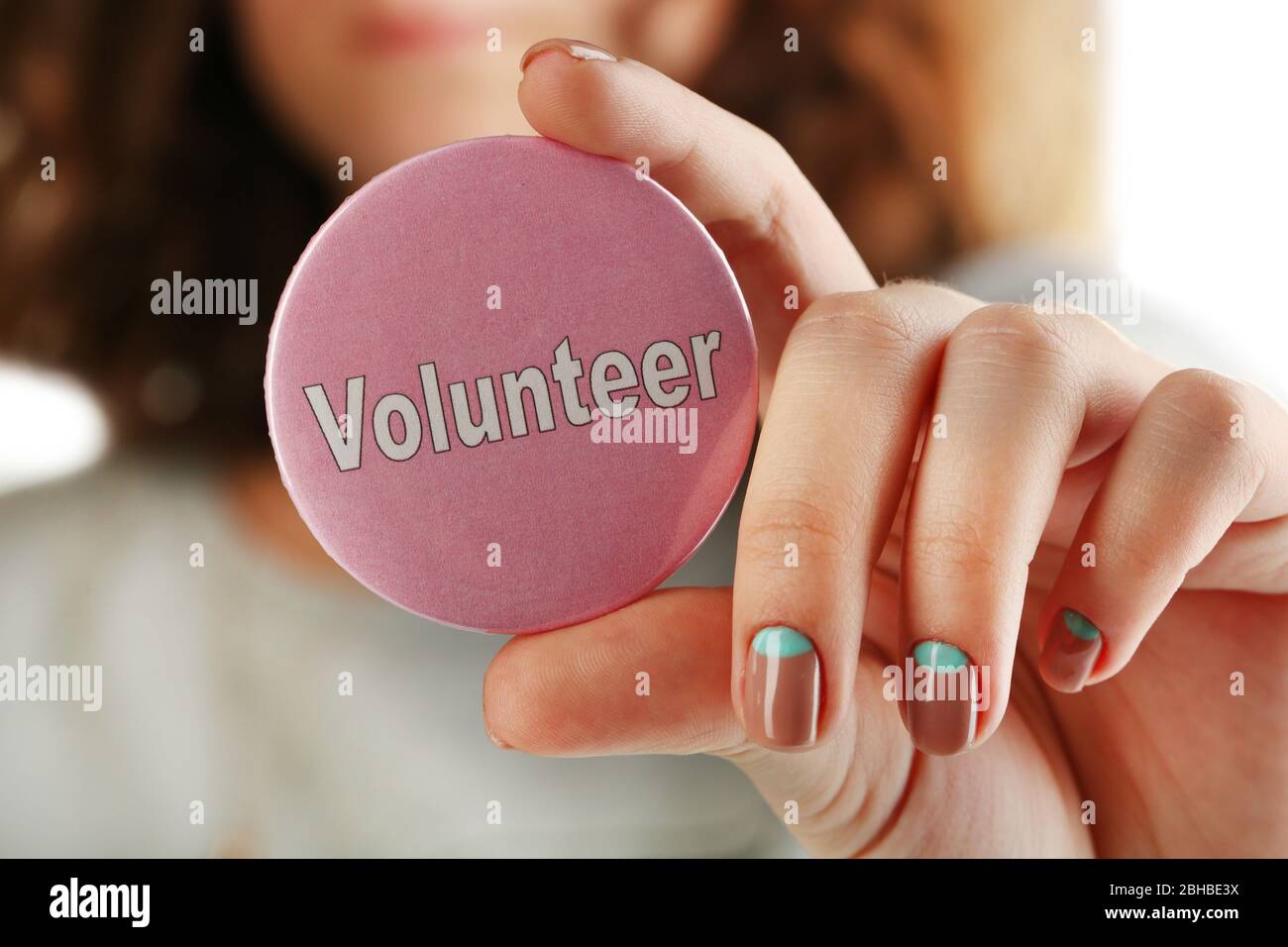 Round volunteer button in hand close-up Stock Photo - Alamy