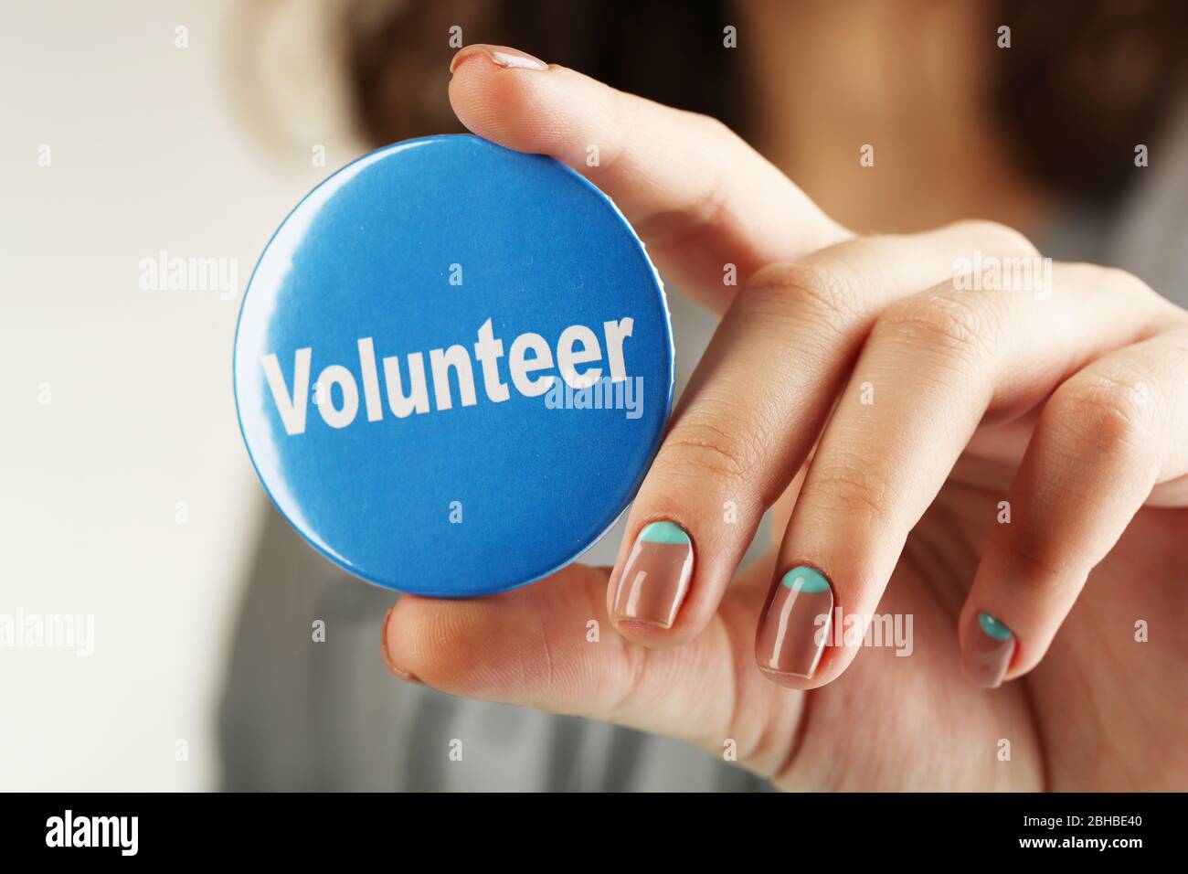 Round volunteer button in hand close-up Stock Photo - Alamy
