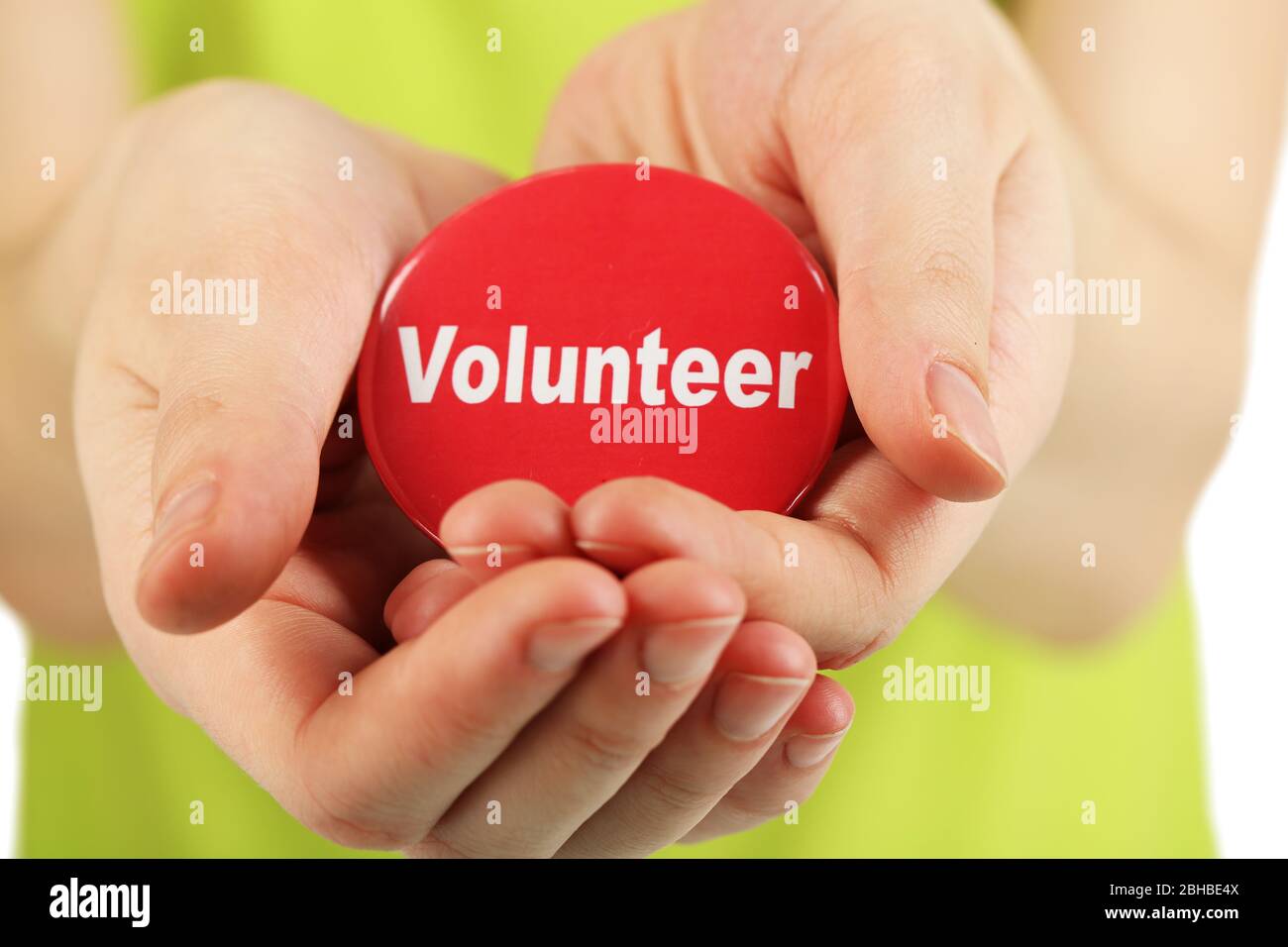Round volunteer button in hands of girl close-up Stock Photo - Alamy