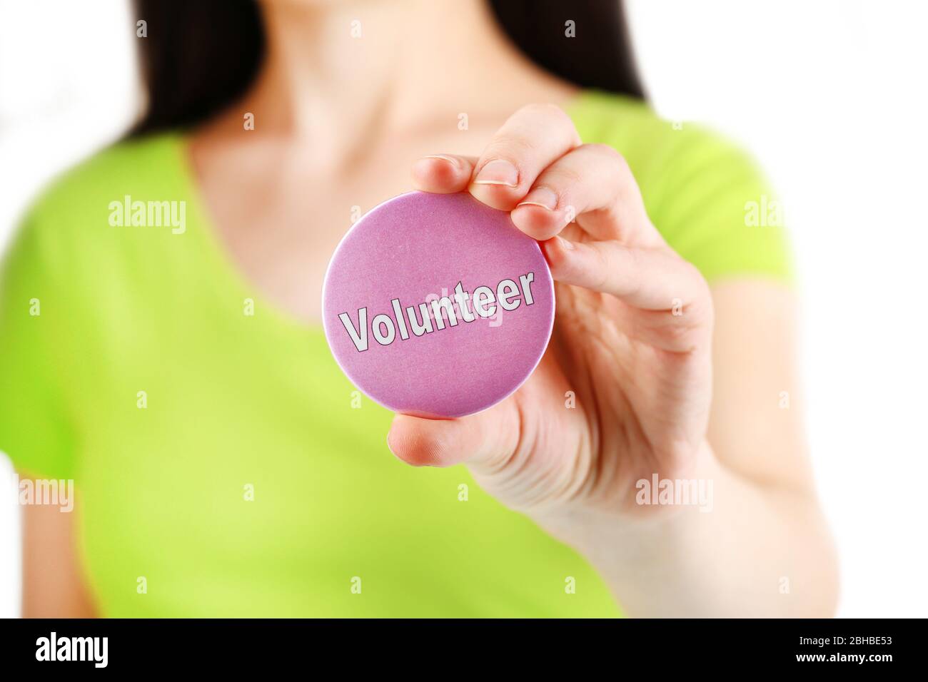 Round volunteer button in hand of girl isolated on white Stock Photo - Alamy