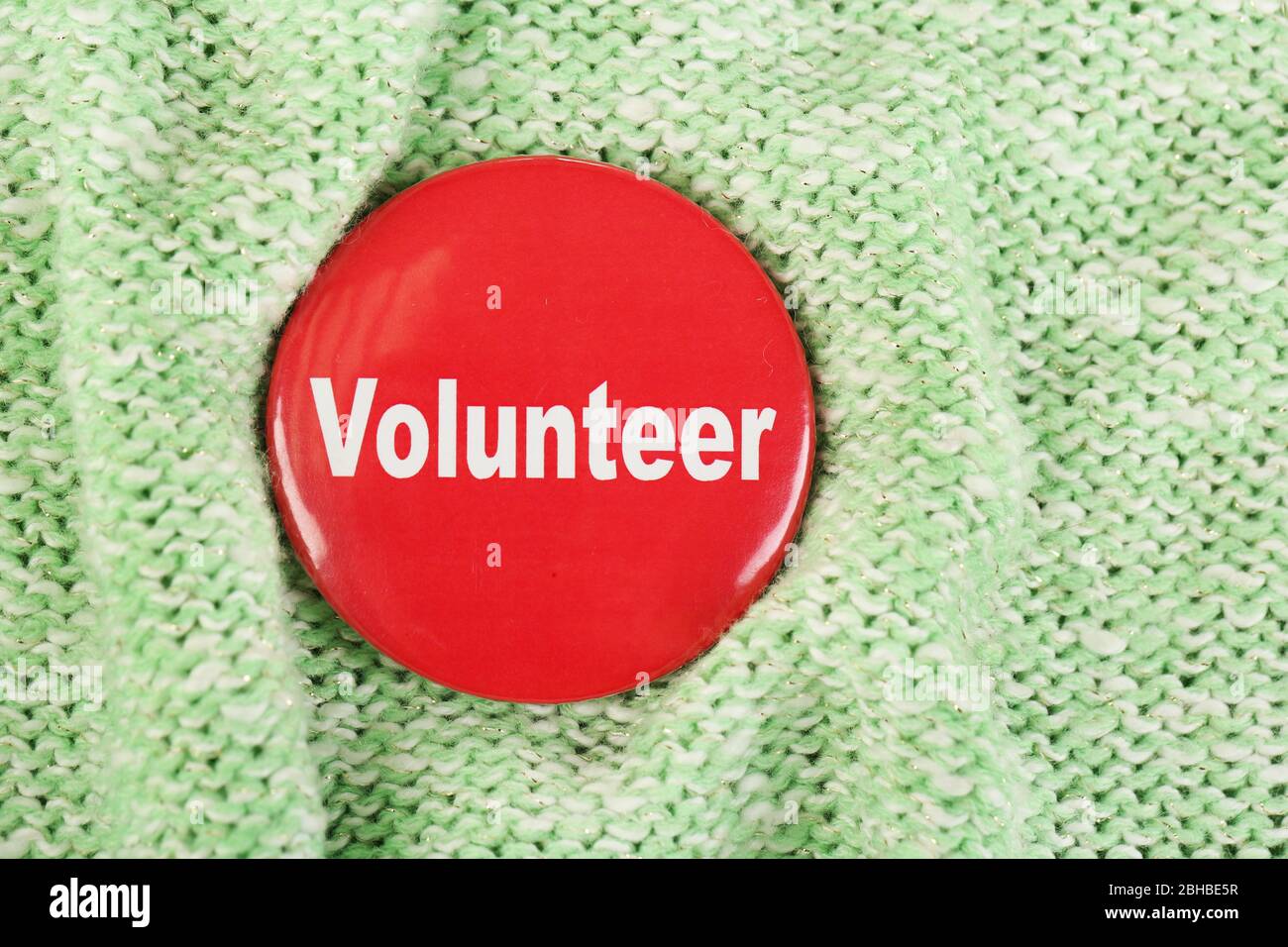 Round volunteer button on cloth background Stock Photo - Alamy
