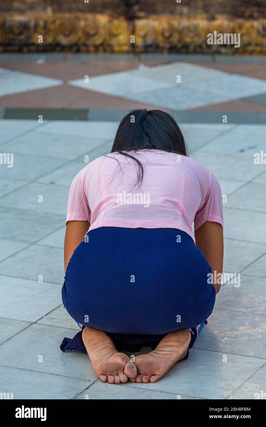 Young Burmese woman praying in front of Shwedagon Pagoda in Yangon ...