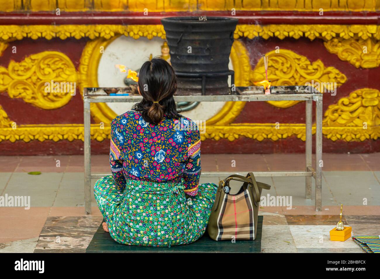 Young Burmese woman praying in front of Shwedagon Pagoda in Yangon ...