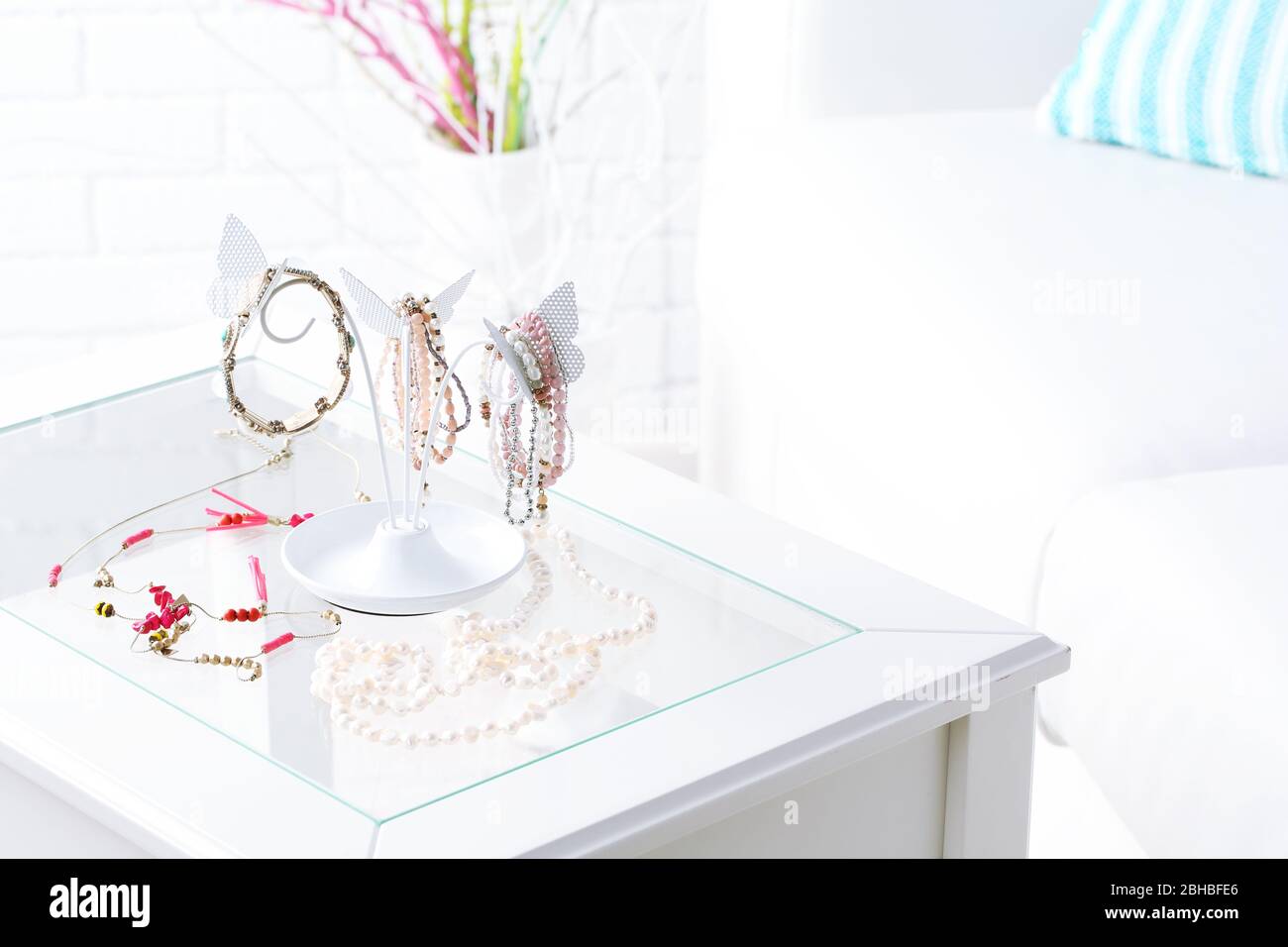 Decorative stand with jewelry and bijouterie on table in room Stock ...