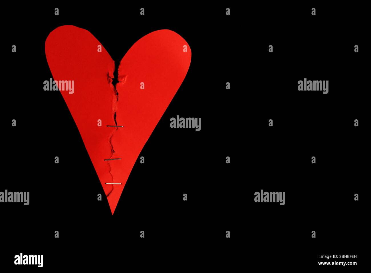 Broken paper heart on black background Stock Photo - Alamy