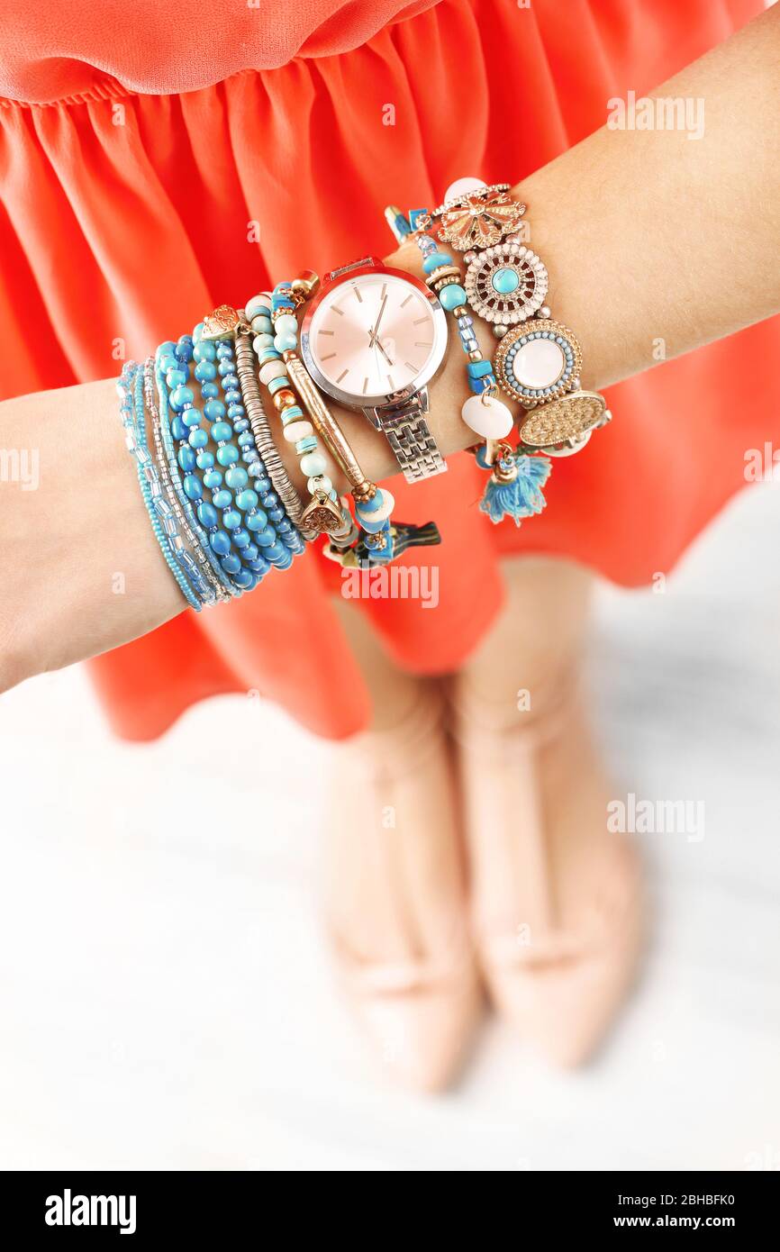 Stylish bracelets and clock on female hand top view Stock Photo - Alamy