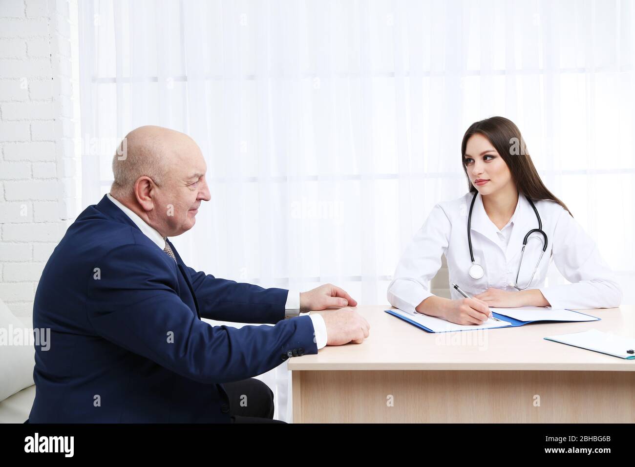 Young female doctor receiving patient in her office Stock Photo - Alamy
