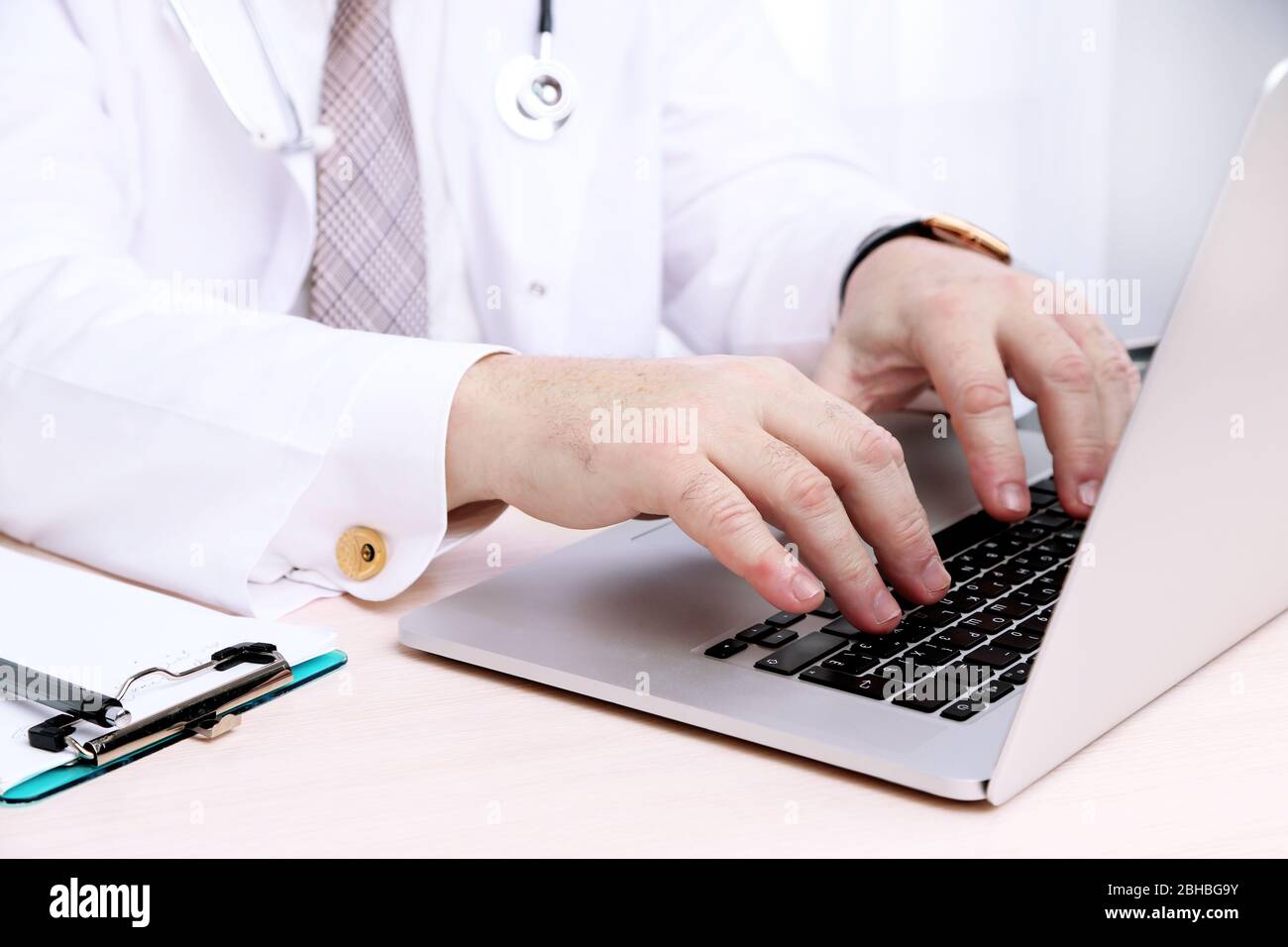 Doctors hands working at notebook in office on white background Stock ...
