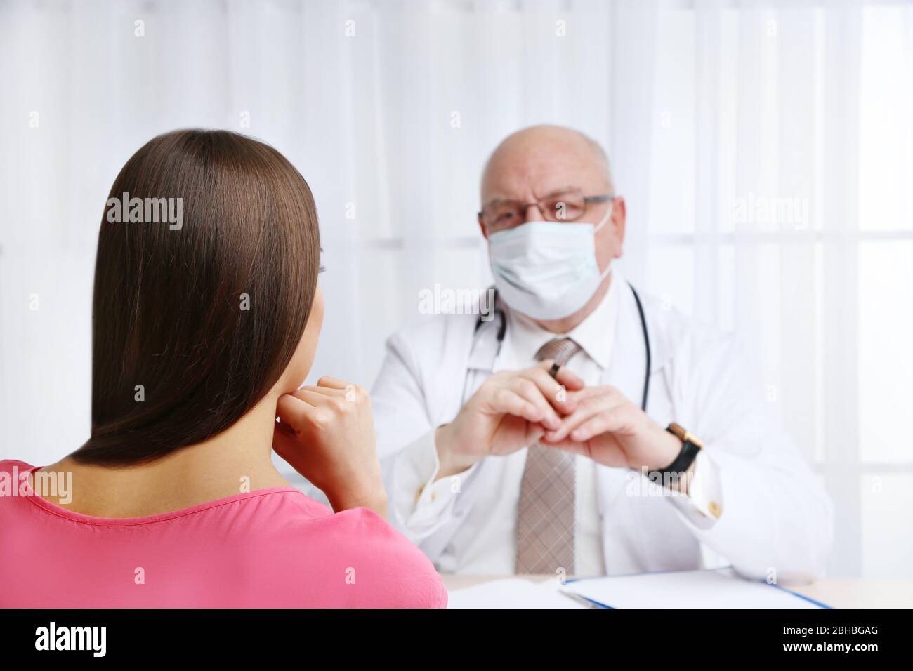 Professional doctor receiving patient in his office on white curtain ...