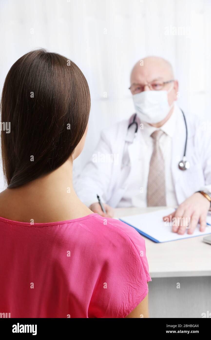 Professional doctor receiving patient in his office on white curtain ...