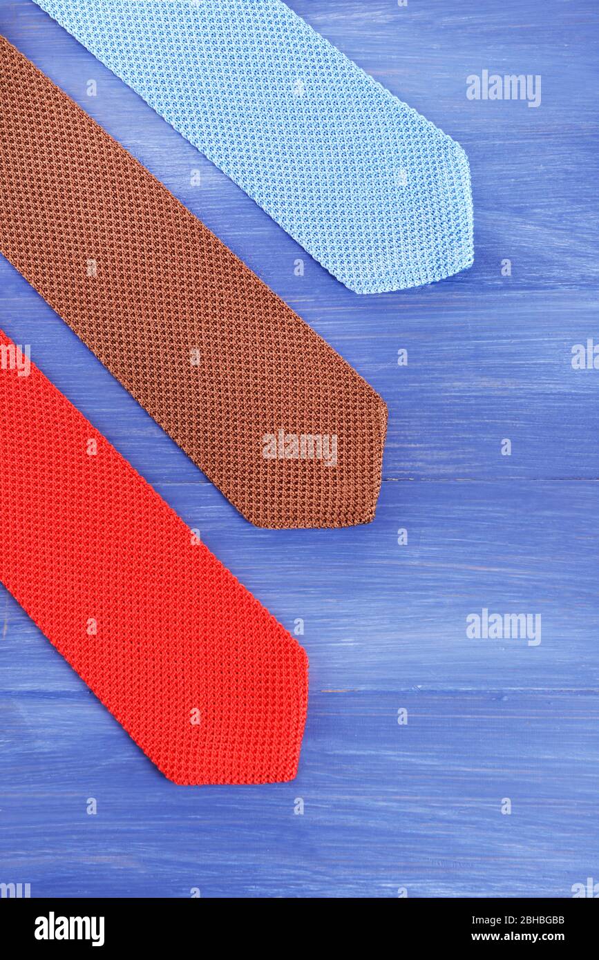 Colorful male ties on color wooden table background Stock Photo - Alamy