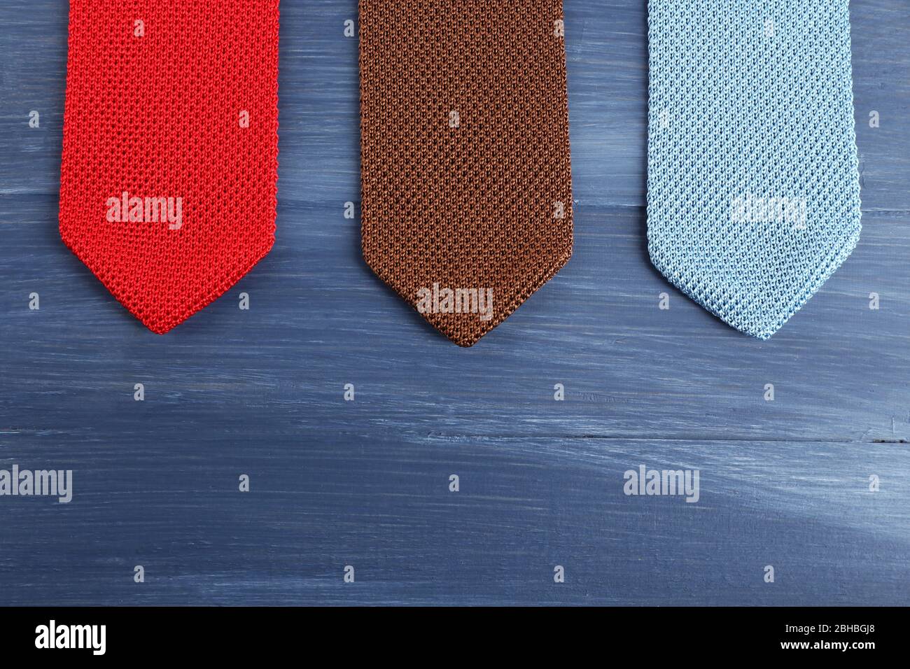 Colorful male ties on color wooden table background Stock Photo - Alamy