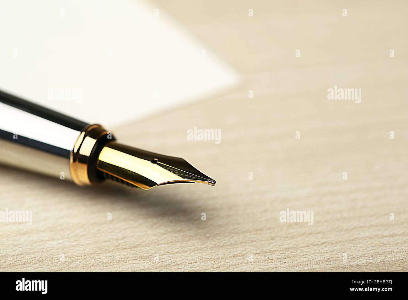Fountain pen on white sheet of paper and wooden table background Stock ...