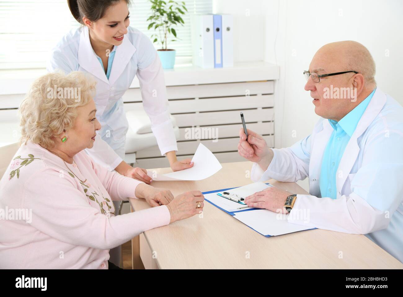 Happy doctors and patient in hospital clinic Stock Photo - Alamy