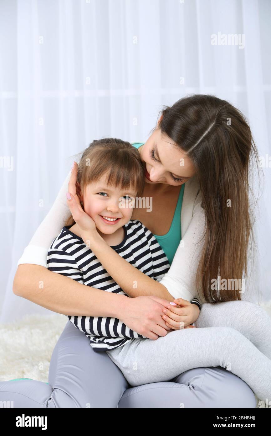 Two girls smiling on light background Stock Photo - Alamy