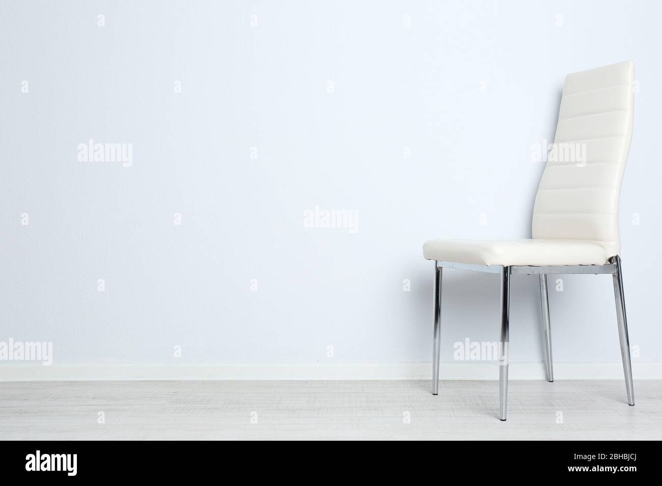 Modern chair on white wall background Stock Photo - Alamy