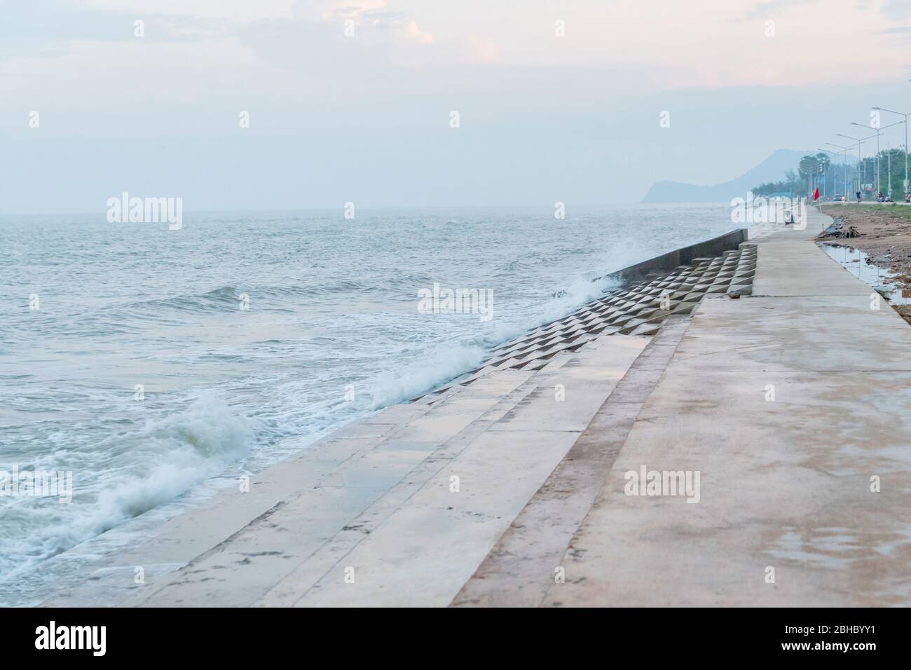 The Strong waves hit concrete sea barrier in the evening Stock Photo ...