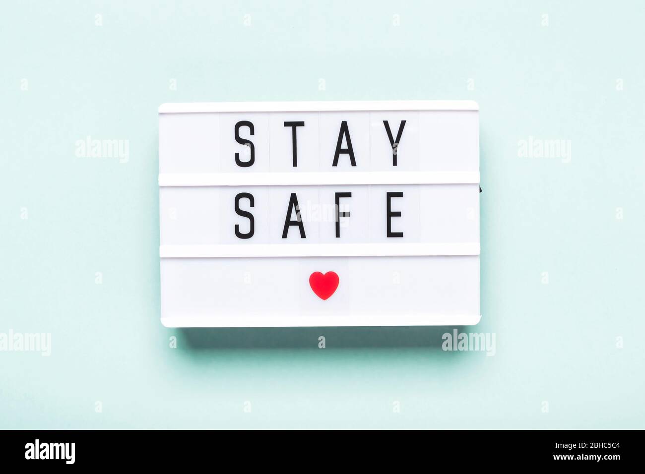 Stay home, stay safe concept. STAY SAVE written on light board on blue ...