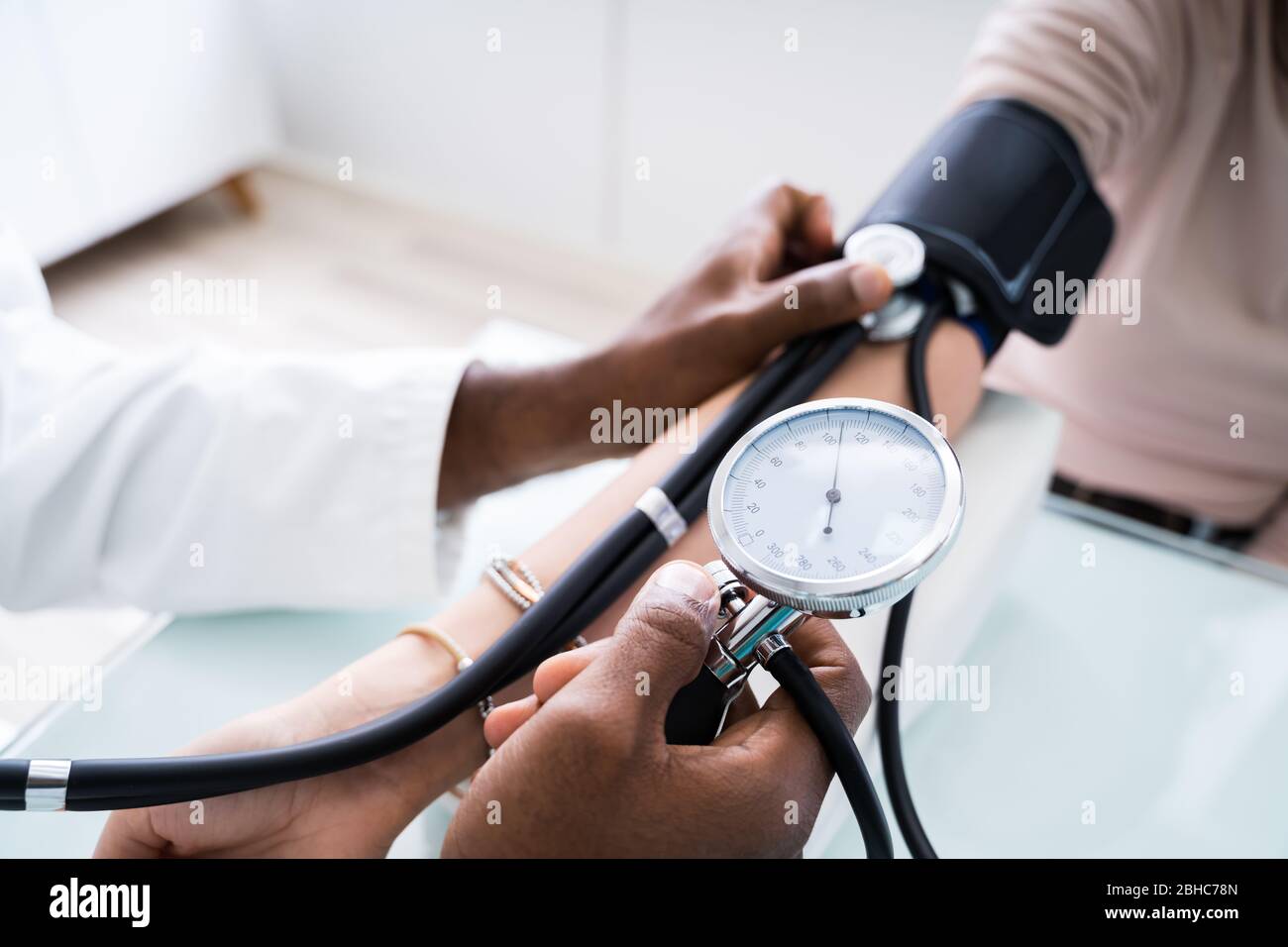Close-up Of Doctor Measuring Patients Blood Pressure With Stethoscope ...