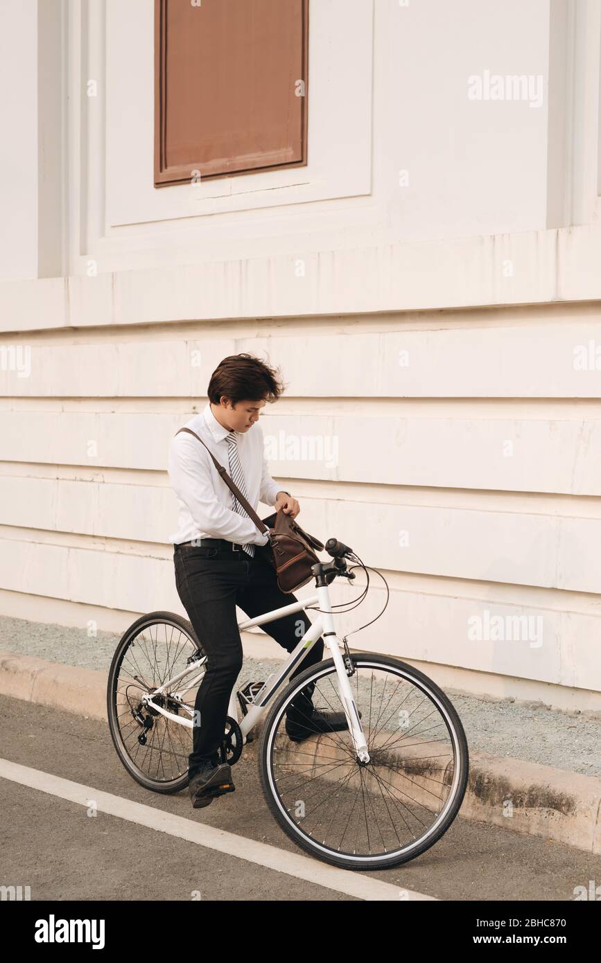 Young businessman searching items in his bag Stock Photo - Alamy