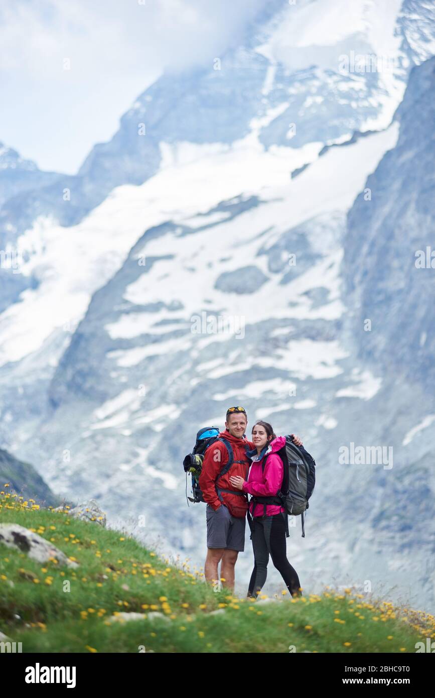 Portrait of couple of tourists travelling in Swiss Alps, man and woman ...