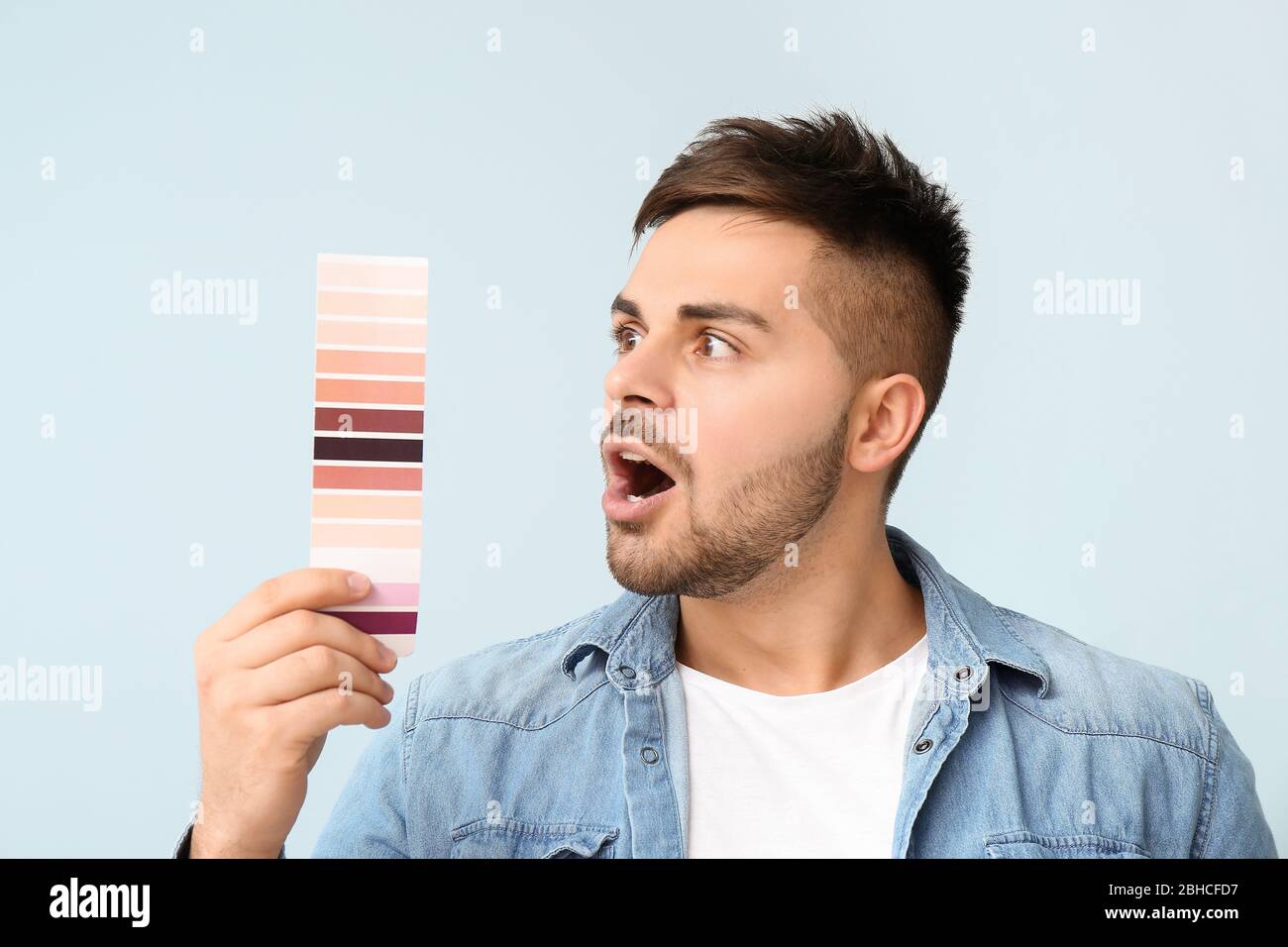 Shocked man with paint palette on color background Stock Photo - Alamy