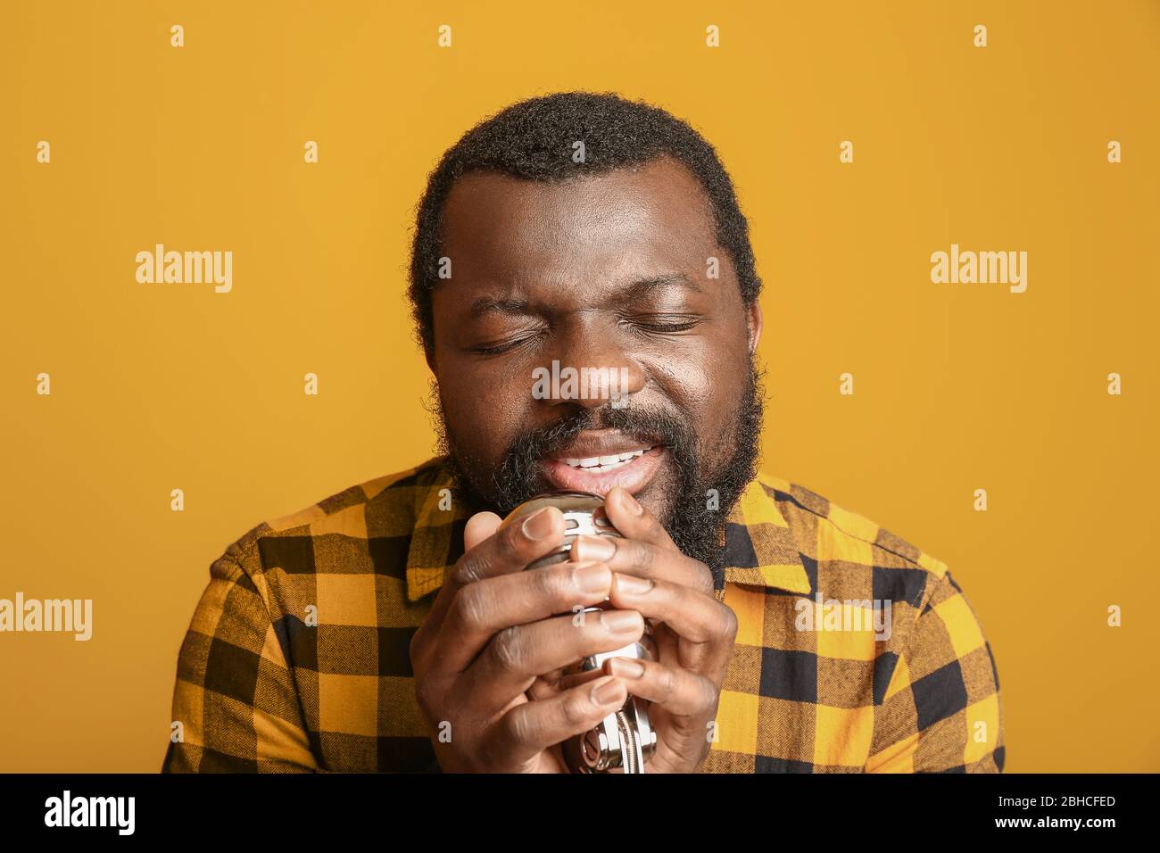 Male African-American singer on color background Stock Photo - Alamy
