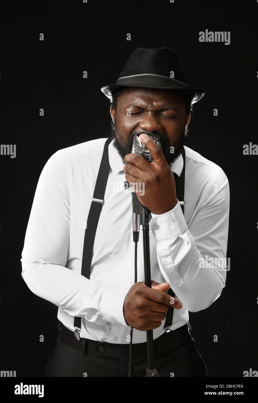Male African-American singer on dark background Stock Photo - Alamy