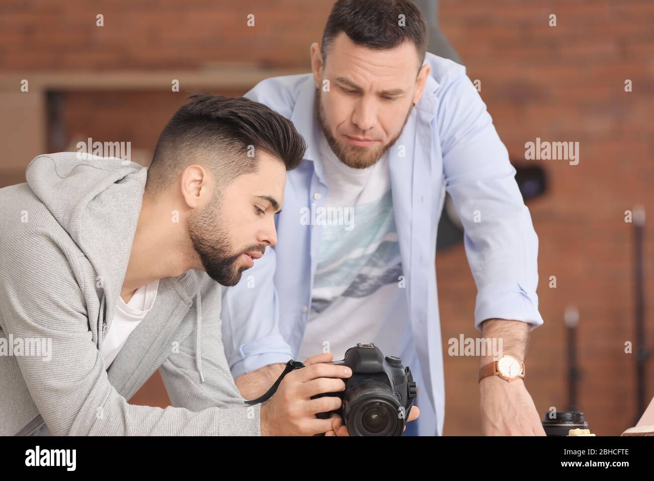 Mentor teaching young photographer in studio Stock Photo - Alamy