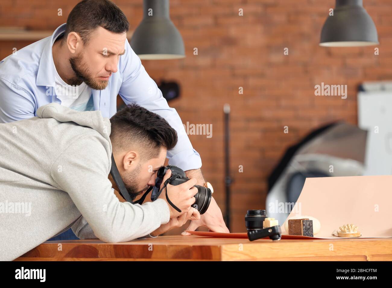 Mentor teaching young photographer in studio Stock Photo - Alamy