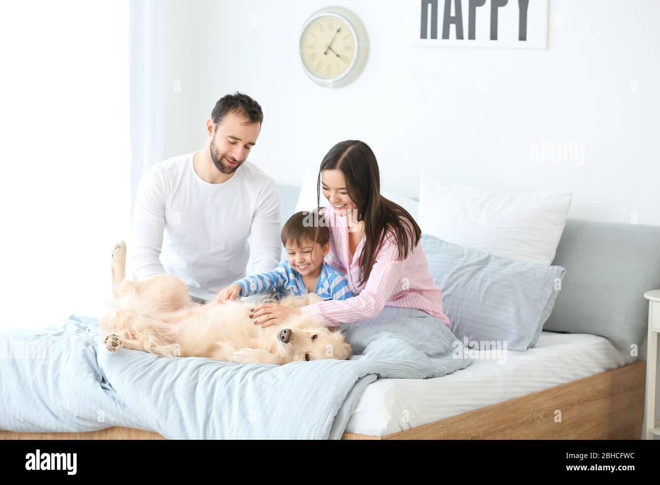 Happy family with dog in bedroom at home Stock Photo - Alamy