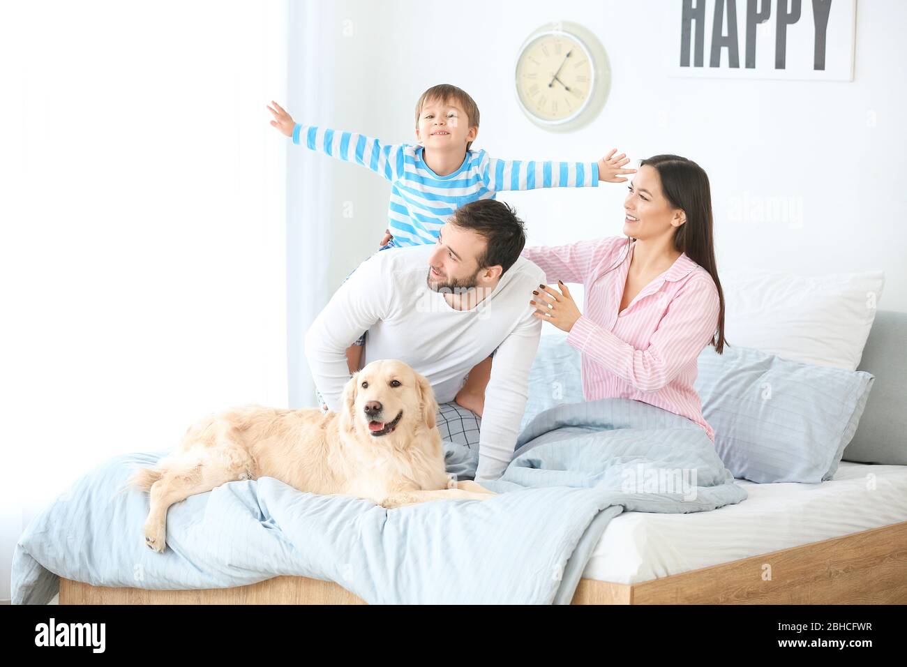 Happy family with dog in bedroom at home Stock Photo - Alamy